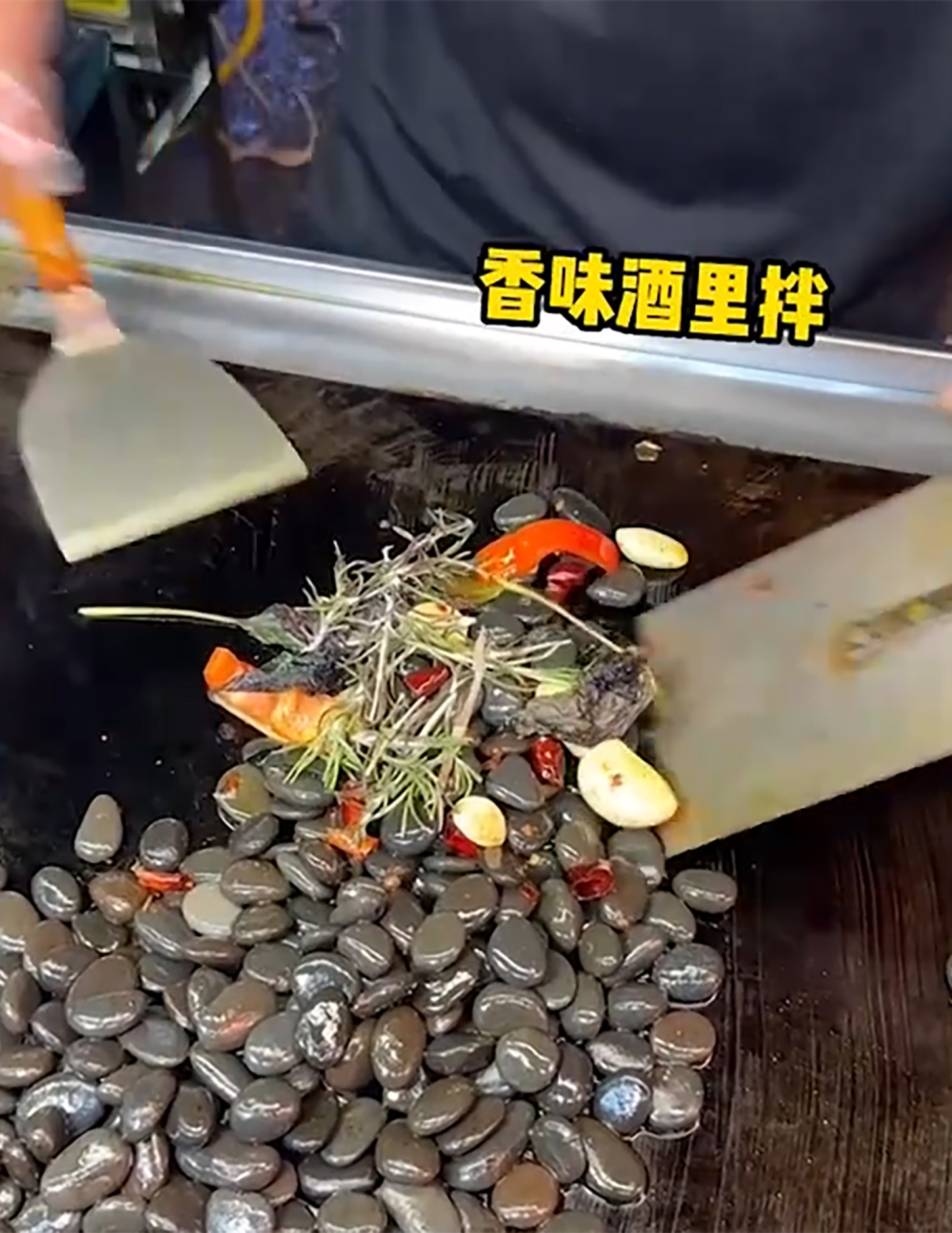 Chinese street vendor sells stir-fried pebbles with chilli and garlic ...