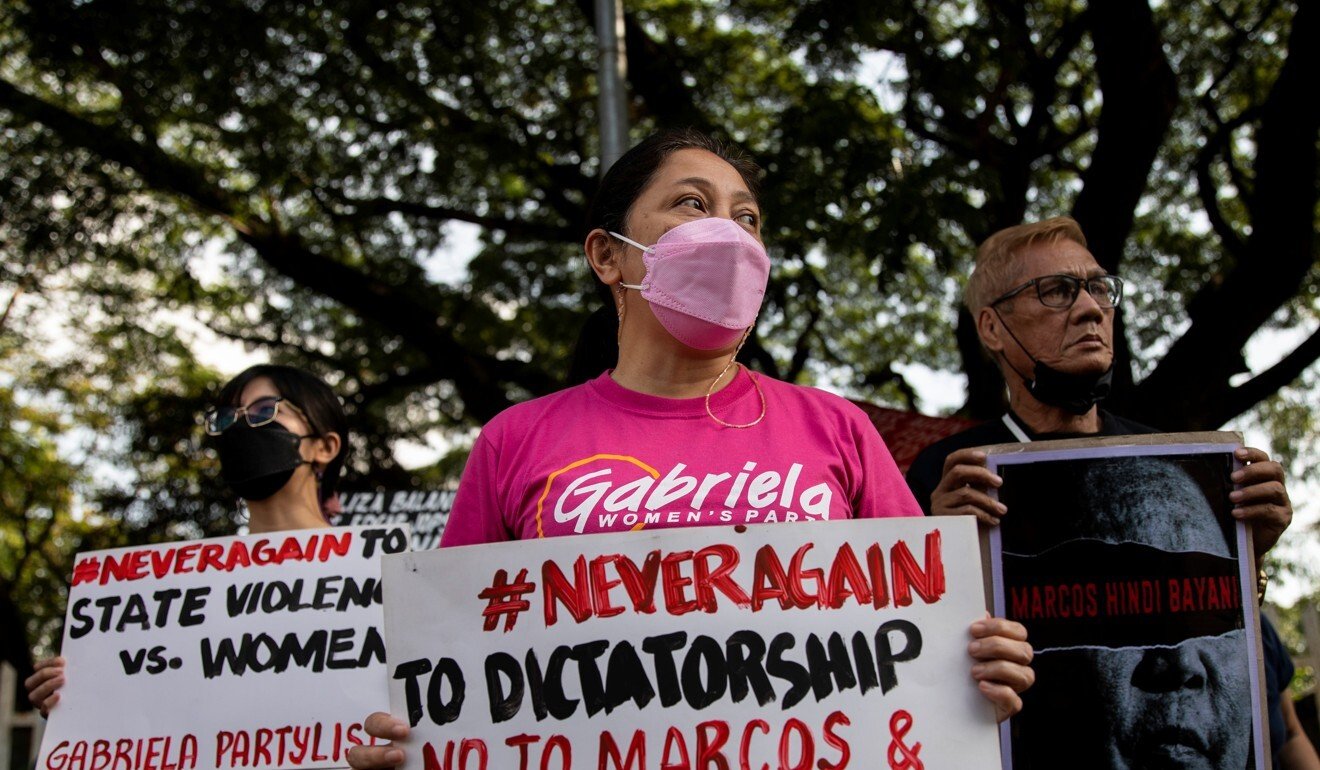 Filipino protesters carry ‘Marcos is no hero’ and ‘never again’ banners ... Filipino protesters carry ‘Marcos is no hero’ and ‘never again’ banners ...