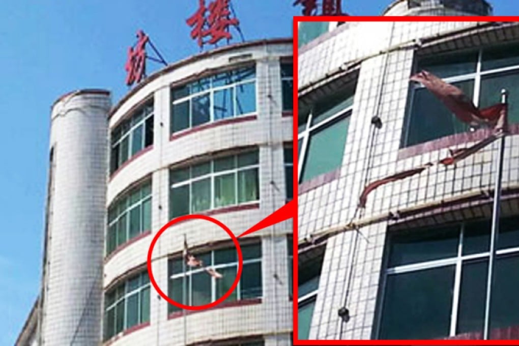 Tattered Chinese national flag flying outside government building ...