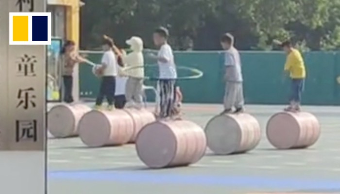 Children practise tricks while walking on cylinder in kindergarten ...
