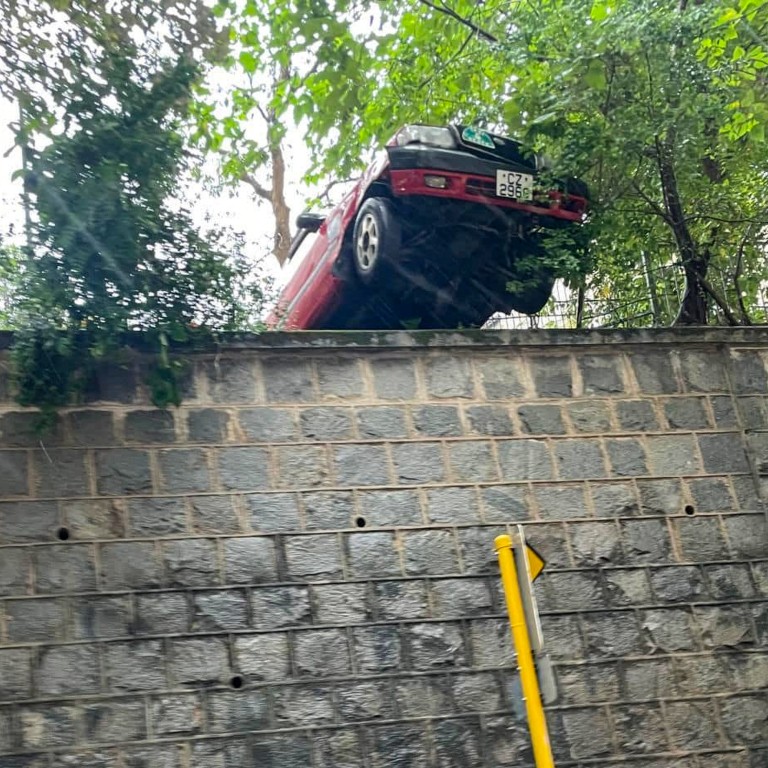 Hong Kong taxi left hanging over 5-metre drop after crash; passer-by ...